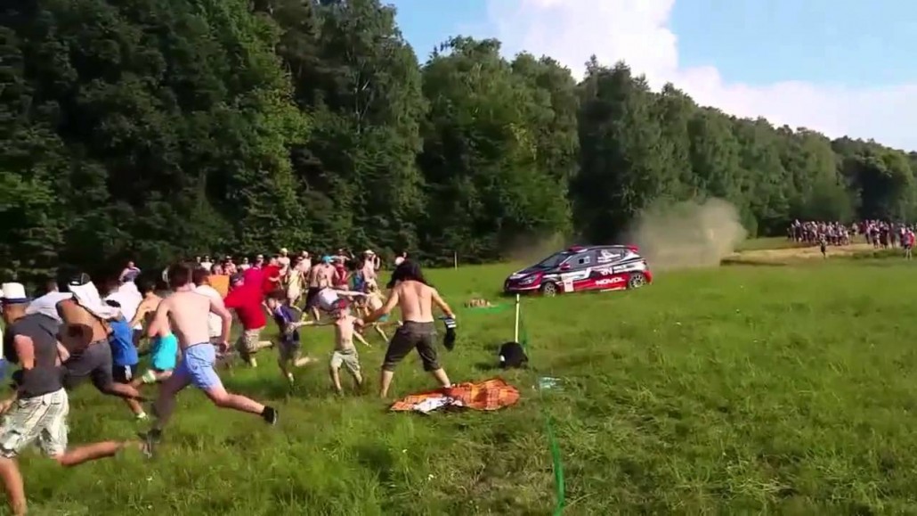 Rallyeauto rast durch Menge - Vater rettet Sohn - Motorblock Rallyeauto rast durch Menge - Vater rettet Sohn - Motorblock
